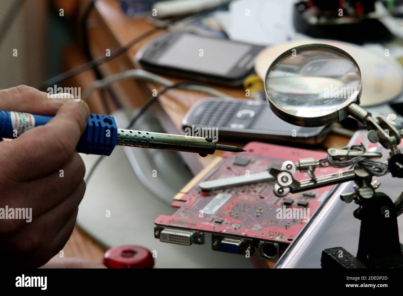 Manual worker human hand holding soldering iron tool repairing computer ...