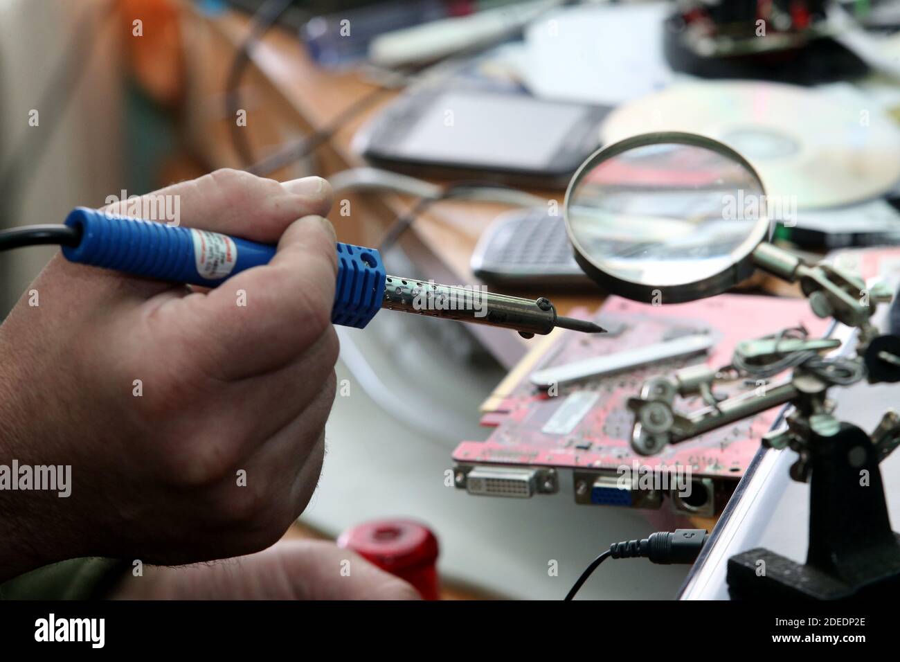 Manual worker human hand holding soldering iron tool repairing computer ...