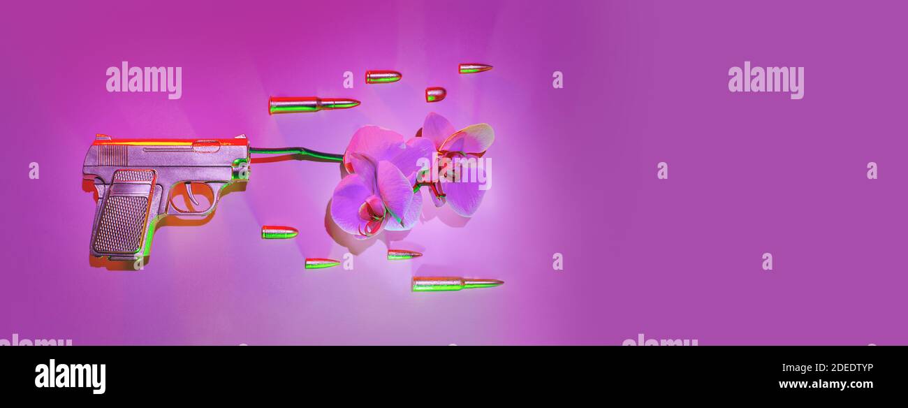 The golden gun shoots an orchid flower, next to fly bullets on a pink ...