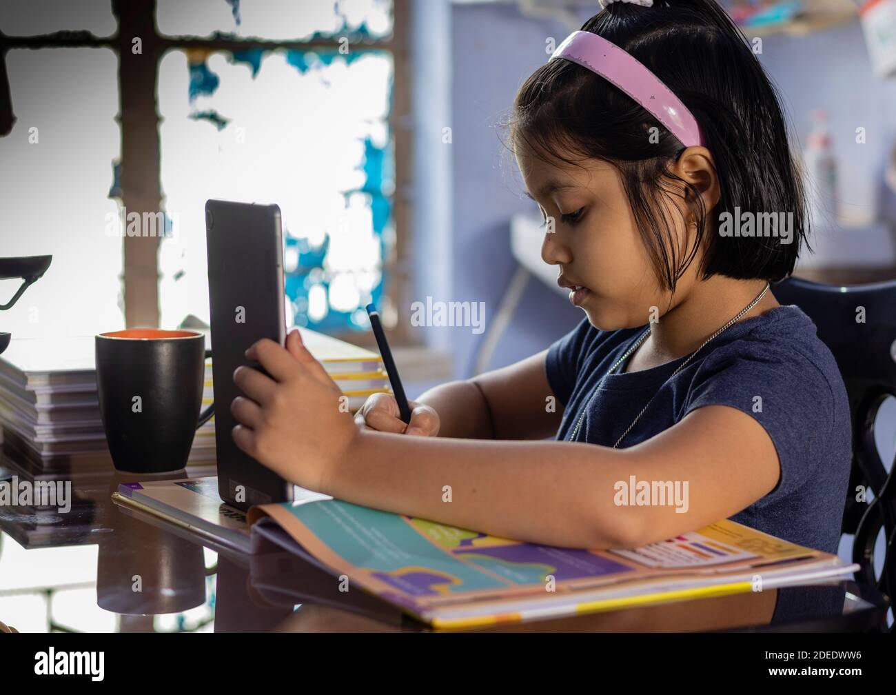 an Indian cute girl child studying at home with tablet Stock Photo - Alamy
