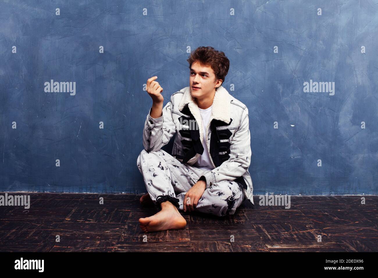 young pretty guy posing emotional cheerful on blue background ...