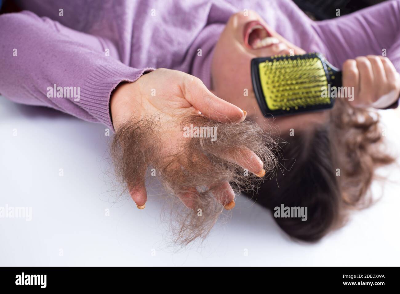 Young girl scared of her hair loss, on a white background Stock Photo ...