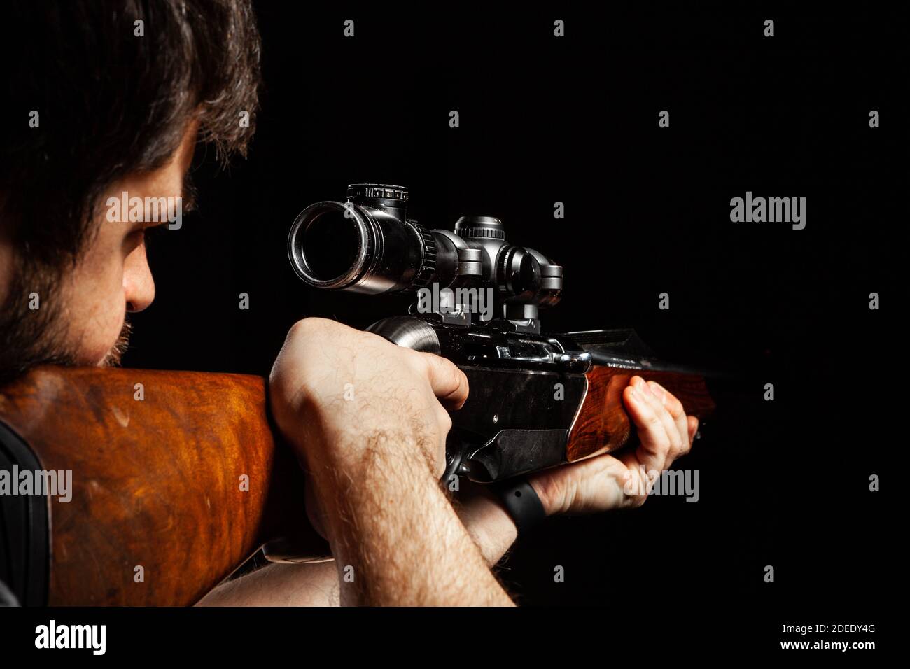 Unrecognizable man aiming with a hunting rifle in dark Stock Photo - Alamy