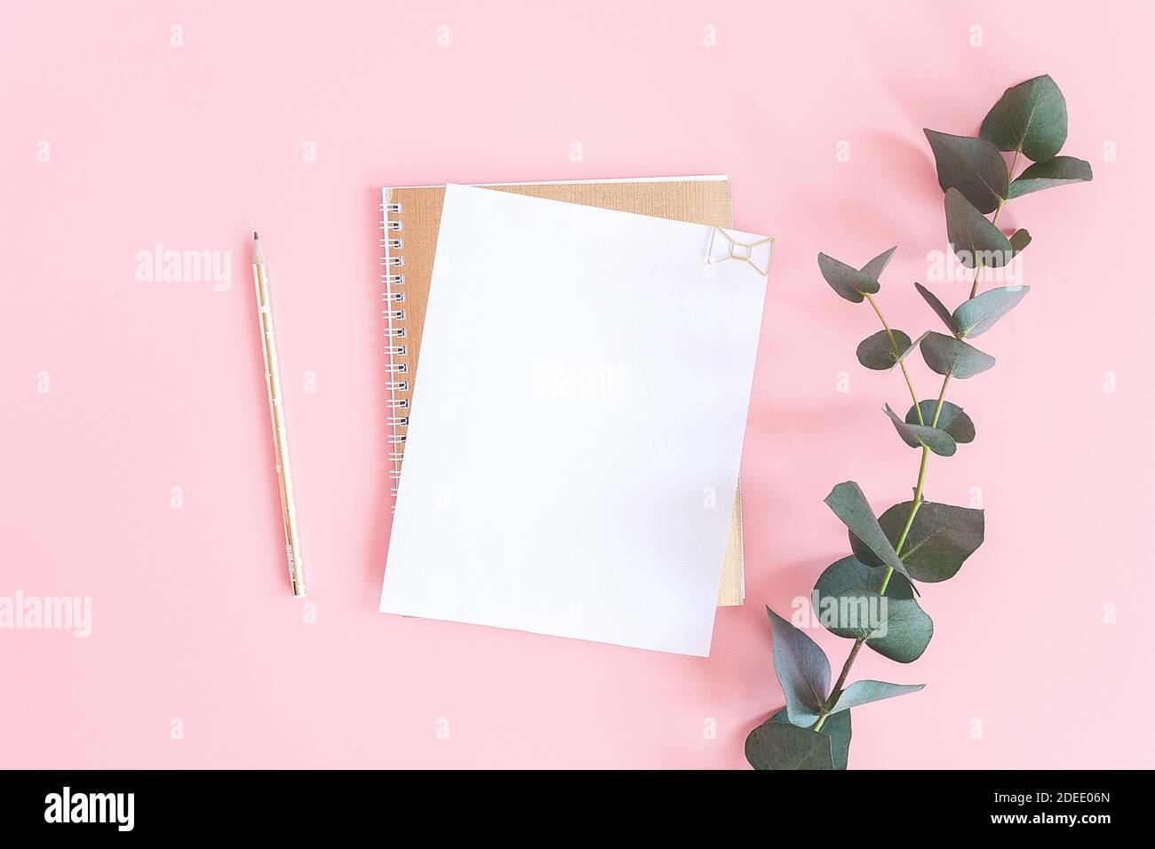 Blank white sheet on spiral golden notepad with paper clip heart ...