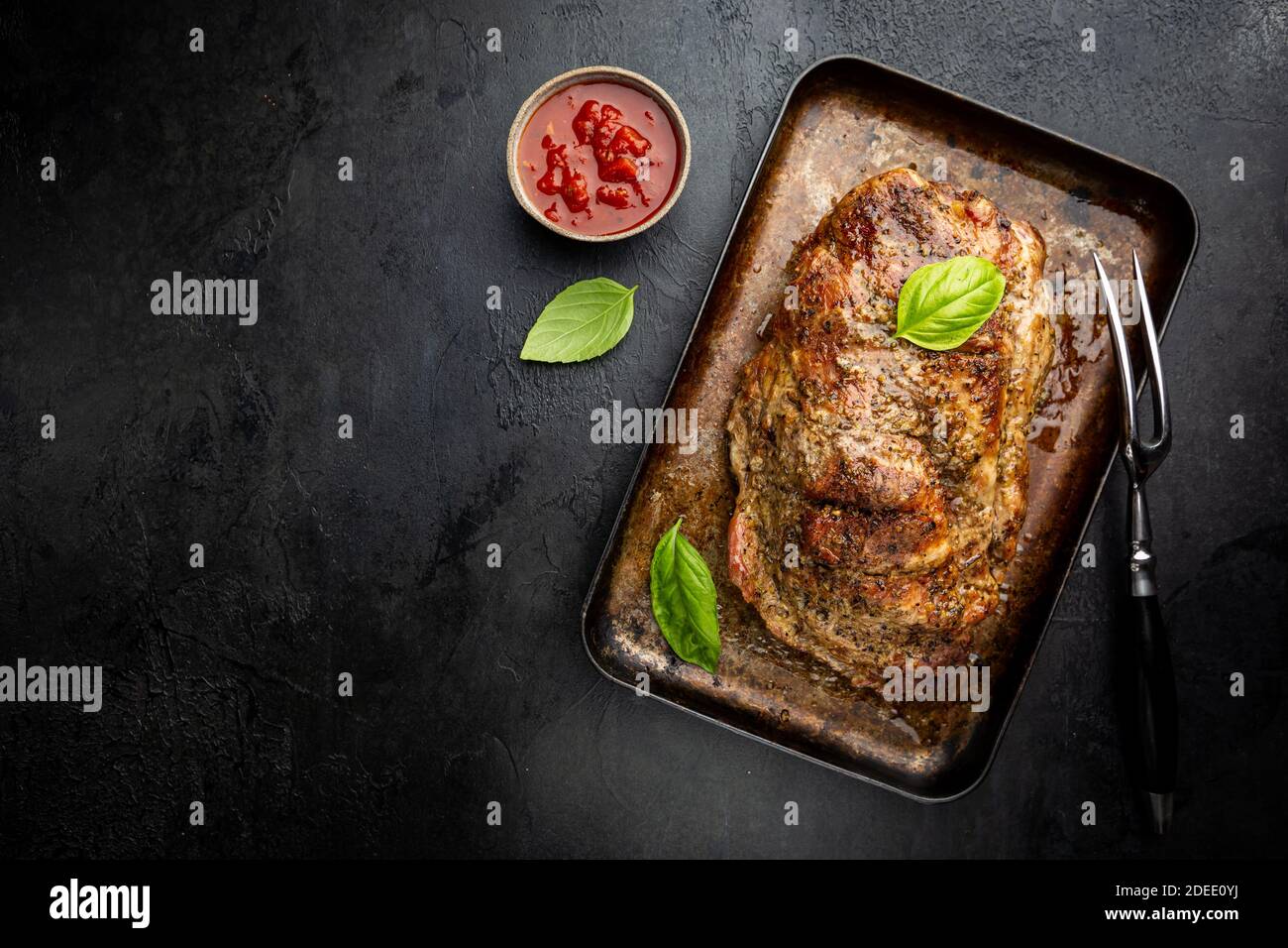 Baked pork meat in a baking pan on dark background, top view Stock ...