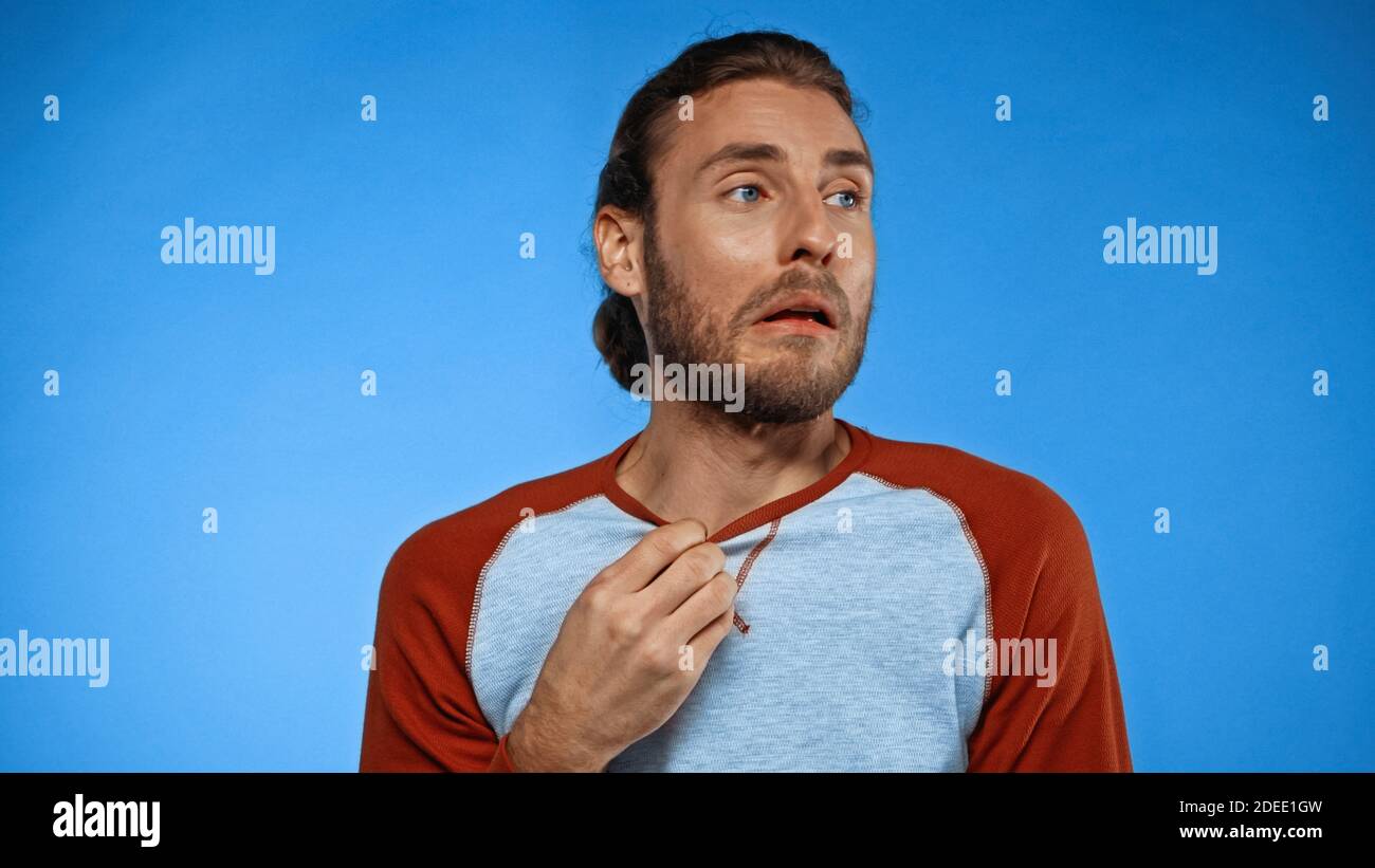 sweaty man feeling hot on blue background Stock Photo - Alamy