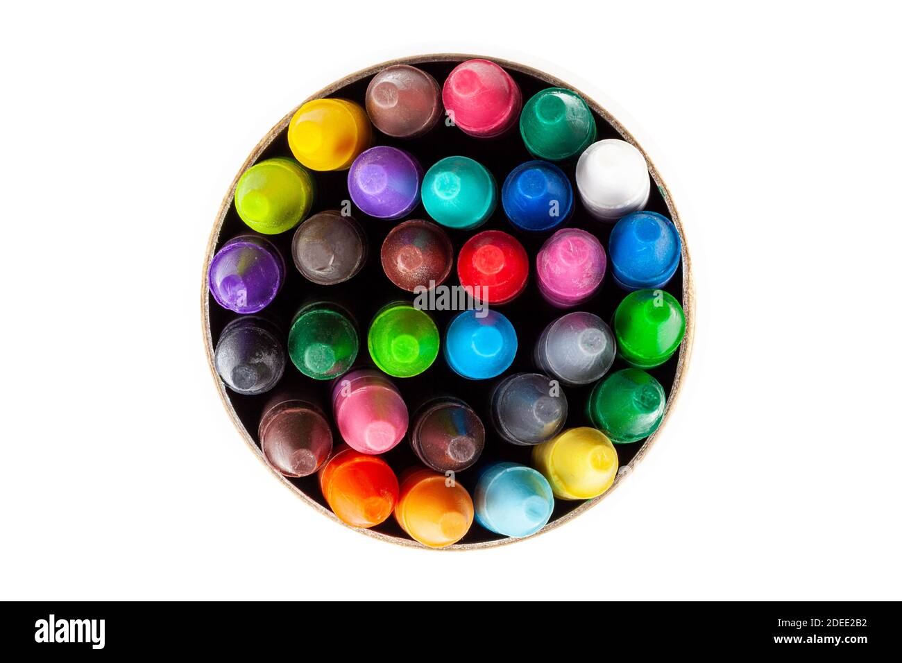 A cylindrical carton tube full of colorful wax crayons seen from above ...