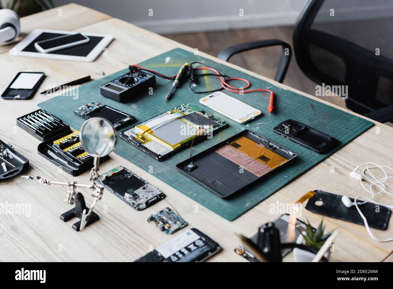 Flat lay of disassembled parts of devices, multi meter, screwdriver and ...