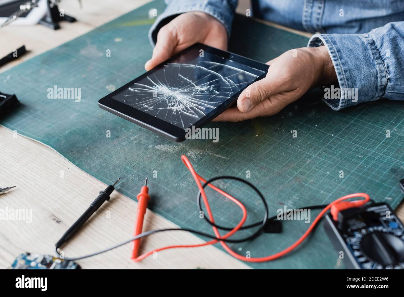 Cropped view of repairman holding smashed digital tablet near ...