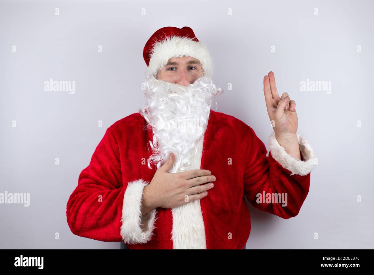 Man dressed as Santa Claus standing over isolated white background ...