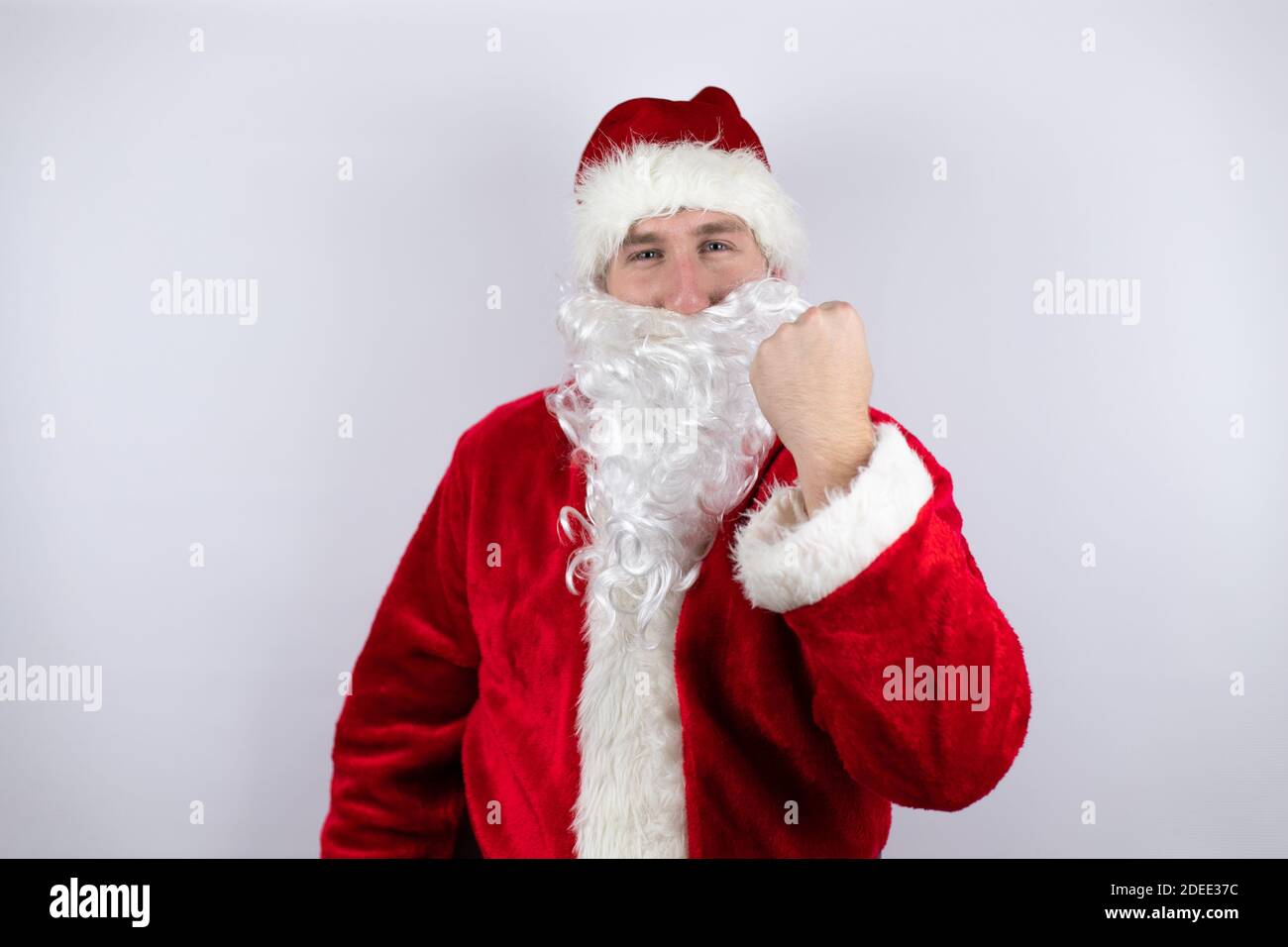 Man dressed as Santa Claus standing over isolated white background ...