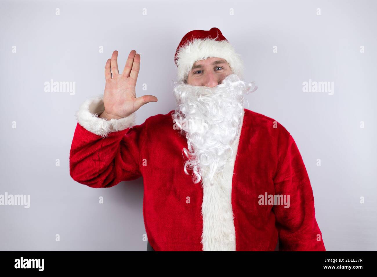 Man dressed as Santa Claus standing over isolated white background ...