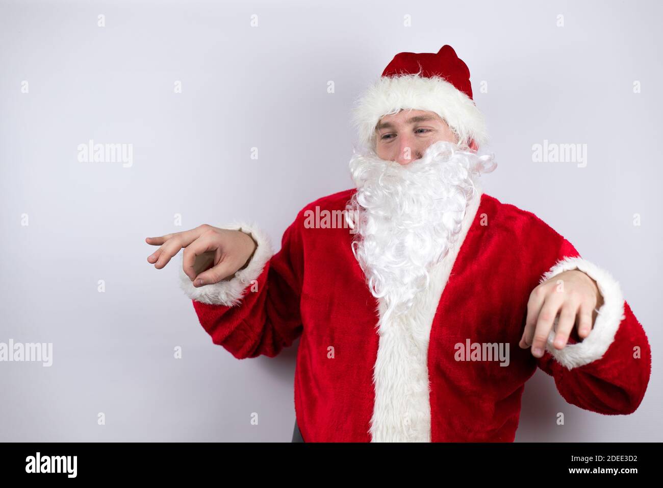 Man dressed as Santa Claus standing over isolated white background ...