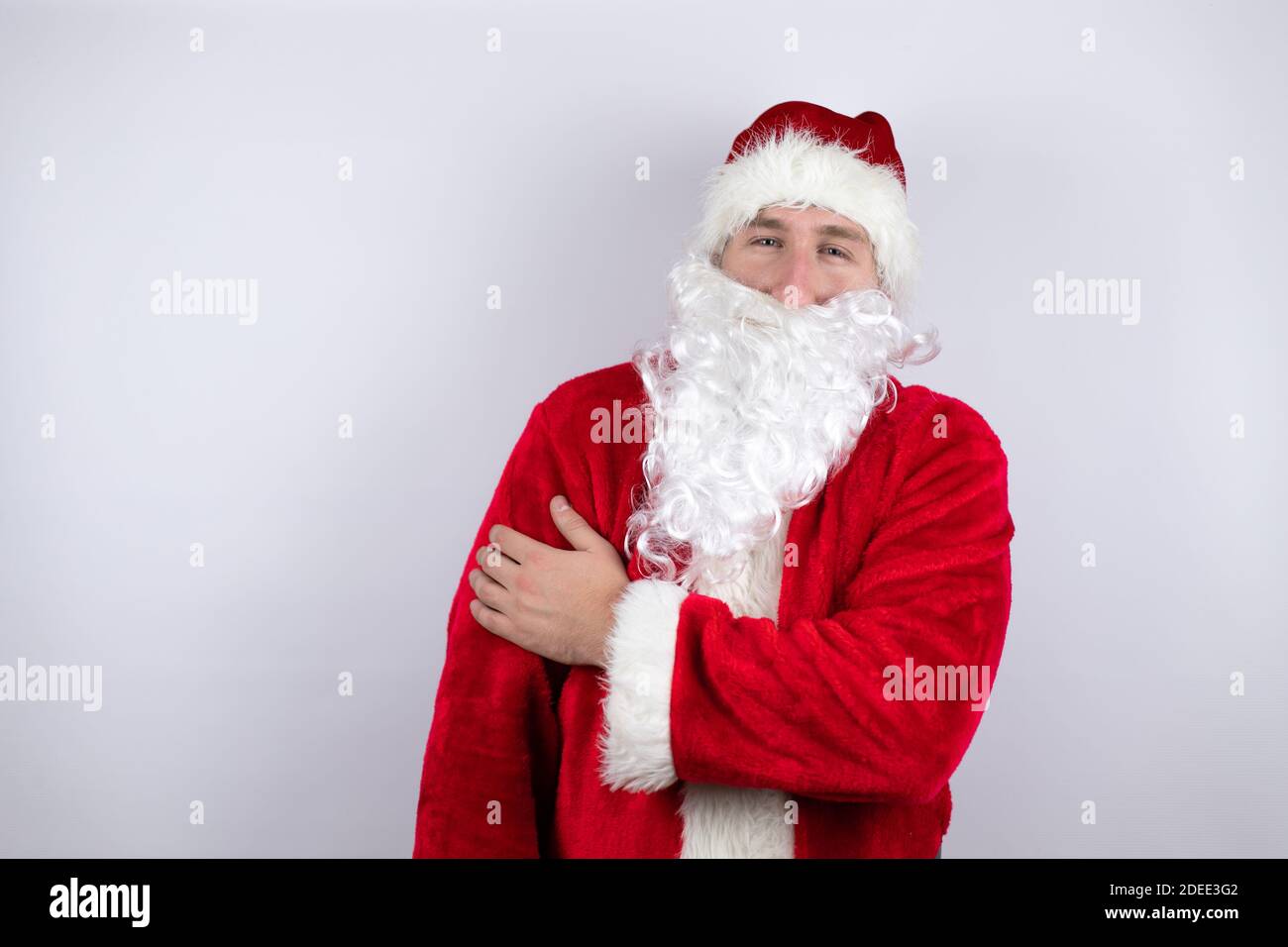 Man dressed as Santa Claus standing over isolated white background with ...