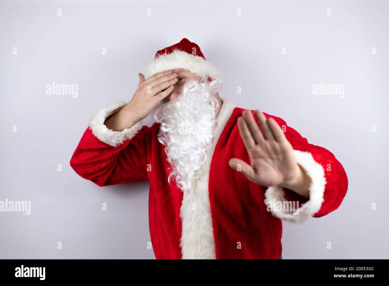 Man dressed as Santa Claus standing over isolated white background ...