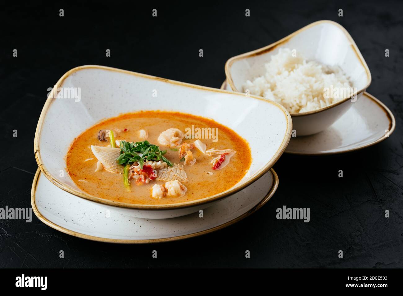 Asian Tom Yam soup with rice on a textured black background Stock Photo ...