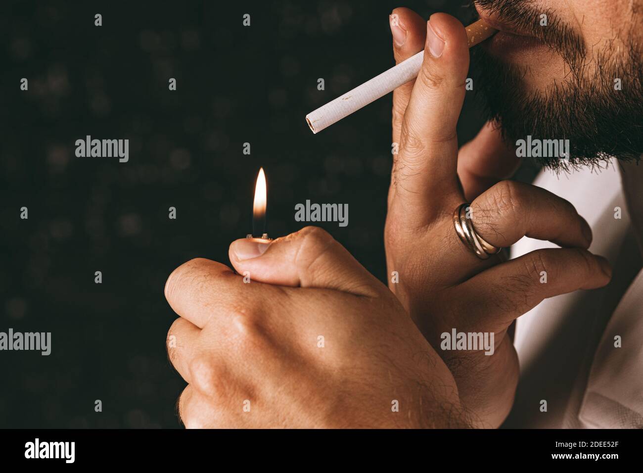 Bearded man lighting cigarette with fire lighter Stock Photo - Alamy