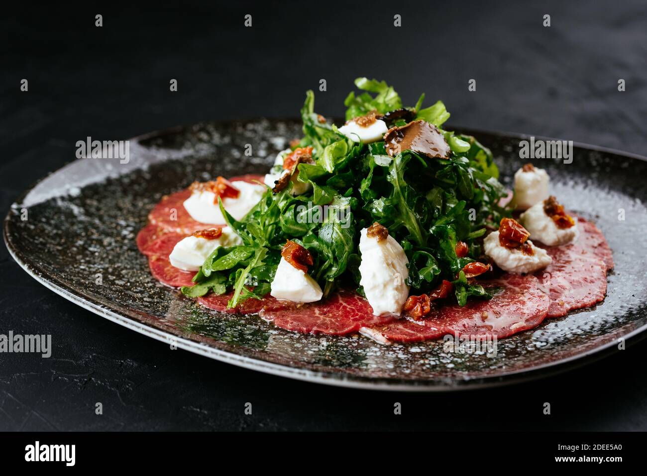 marble beef carpaccio on a black background Stock Photo - Alamy