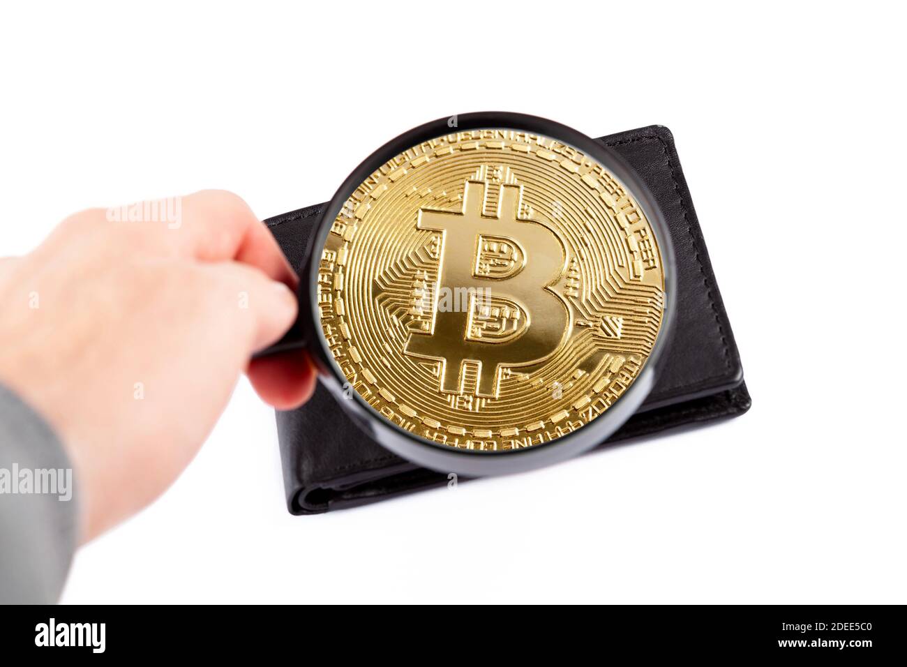 Closer look at a crypto currency wallet, hand holding a loupe revealing ...