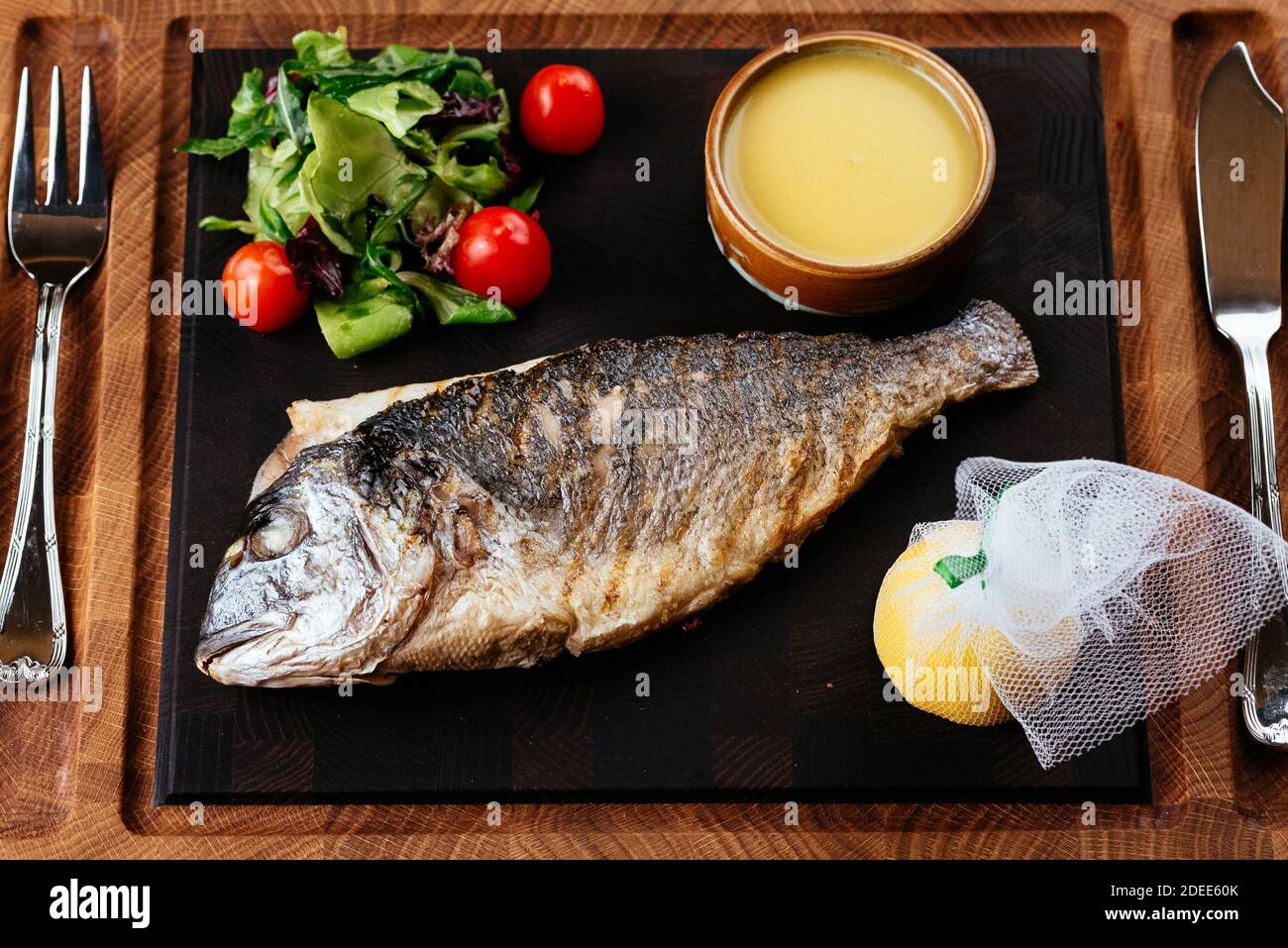 grilled Dorado with vegetables on a black background Stock Photo - Alamy