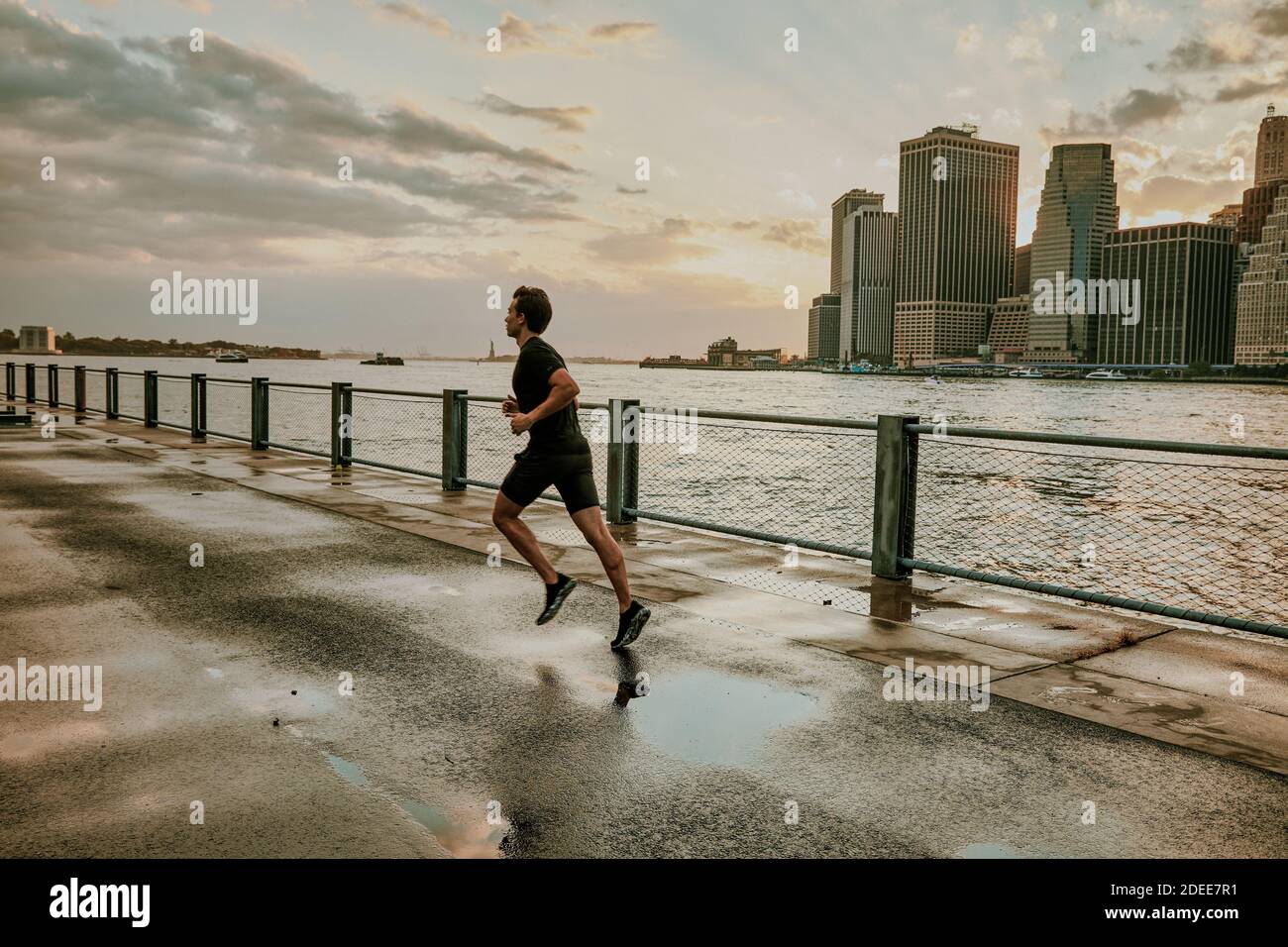 Male athlete running on waterfront during sunset Stock Photo - Alamy