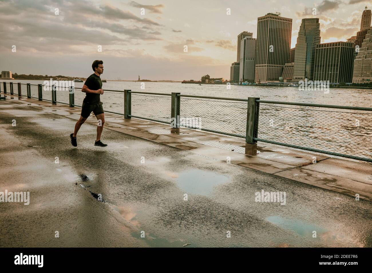 Male athlete running on waterfront during sunset Stock Photo - Alamy