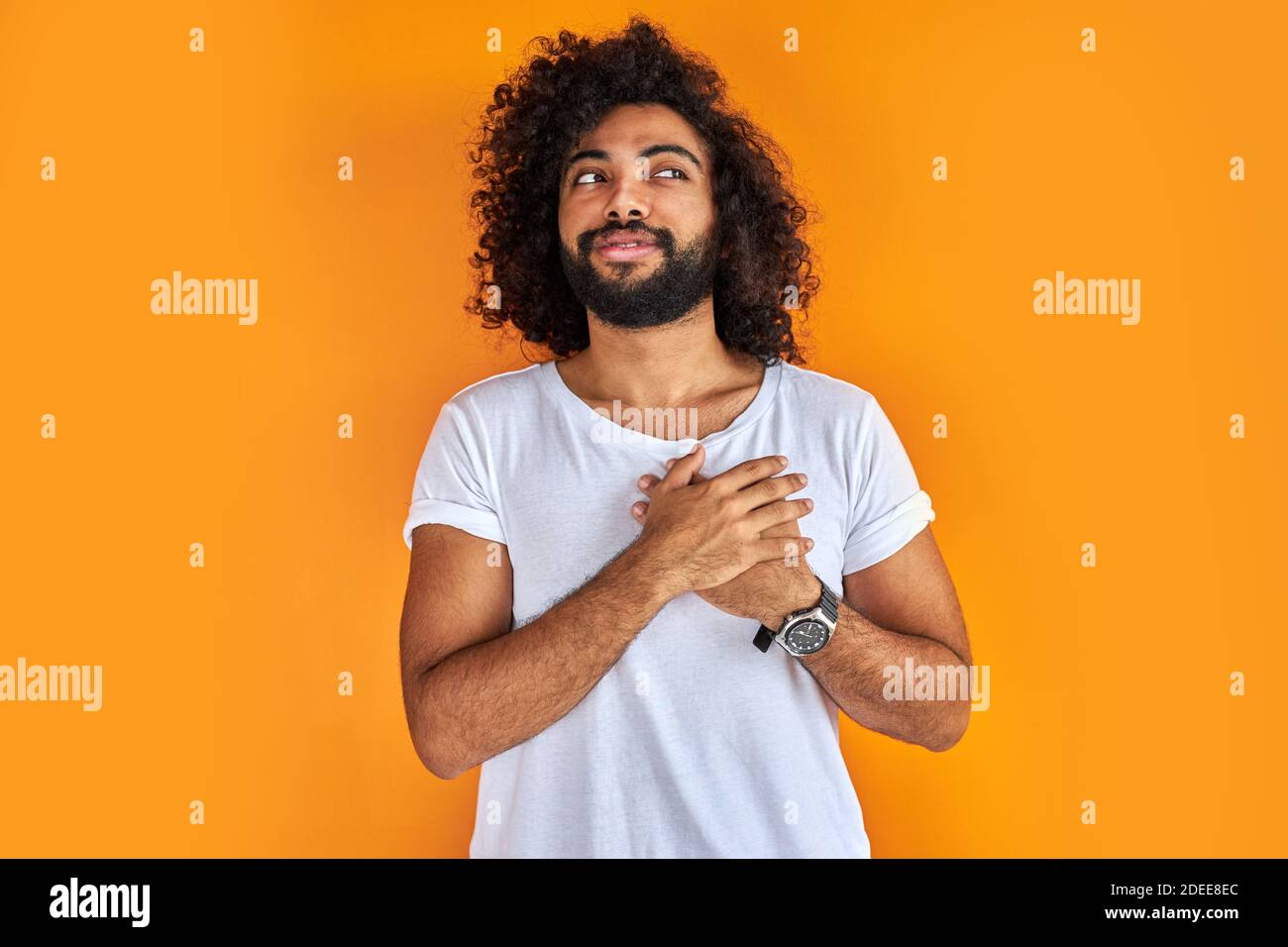 handsome friendly arabic man keeps hands on chest, being cordial and ...