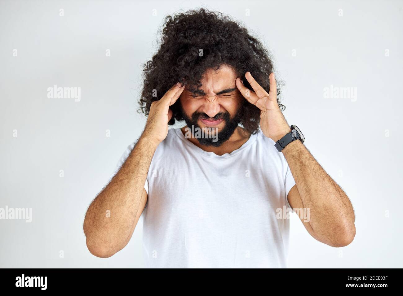 young angry arabic male is having mad expressions, squeezing head with ...