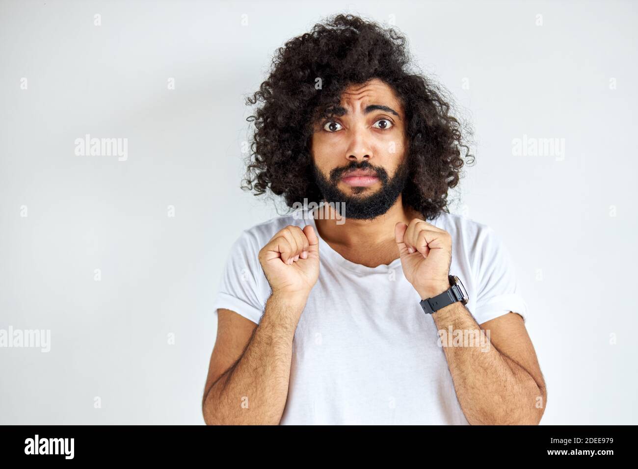 scared curly arabian young guy stand in fear by something, look at ...