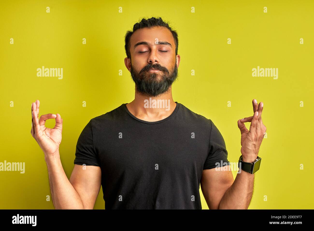 calm arabic man is meditating isolated on green background, yoga ...
