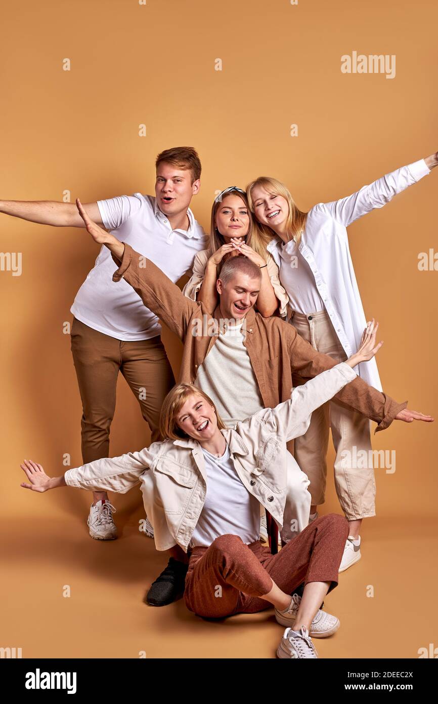 cheerful young people spread arms, ready to fly like a plane, have fun ...