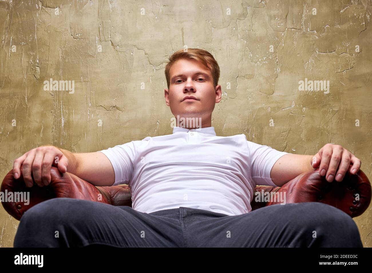 bottom view, from below on bossy caucasian man on leather chair sofa or ...