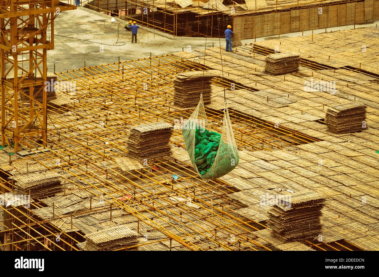 Workers installing yellow metal scaffolding at construction site in ...