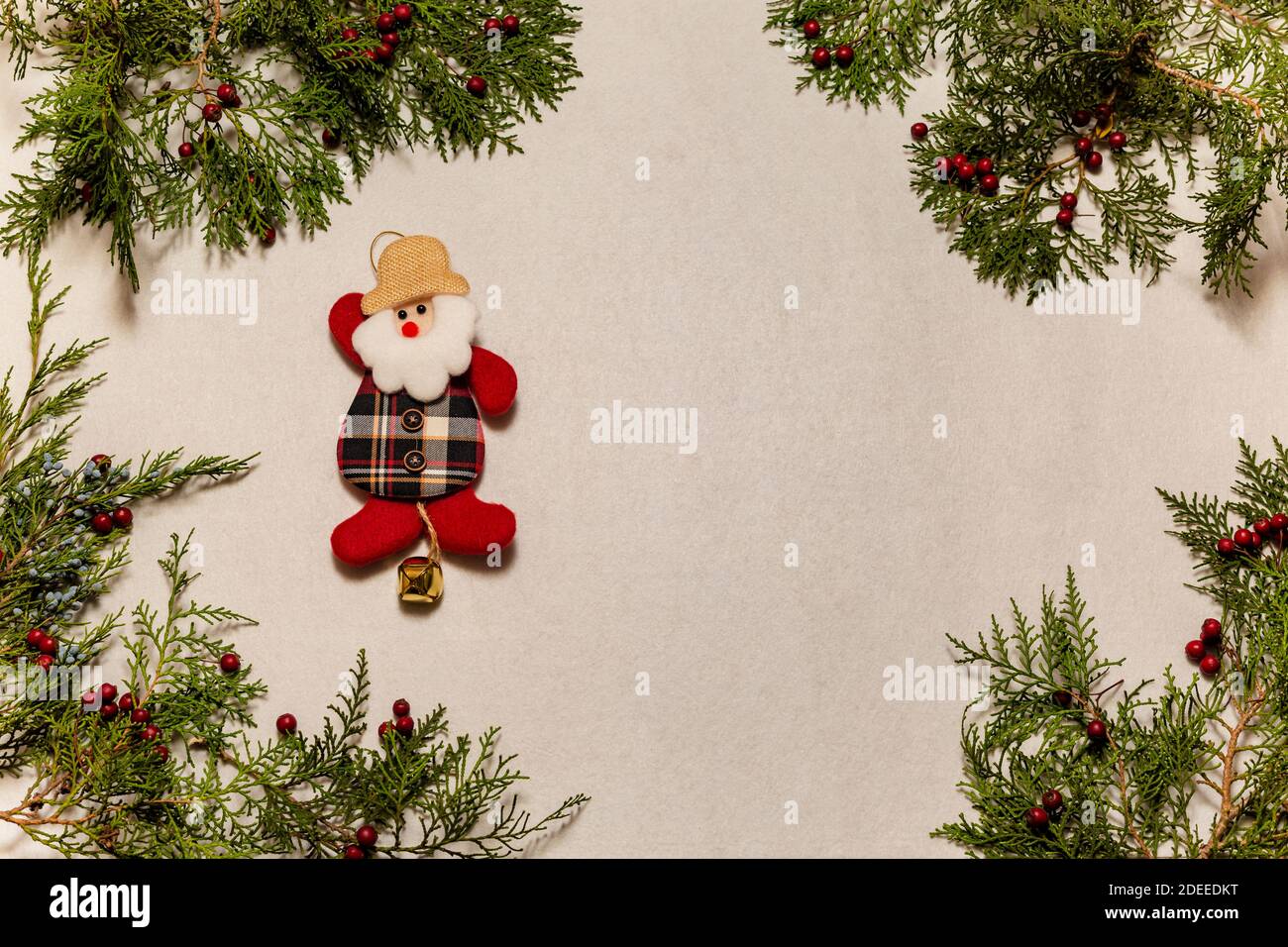 Christmas decoration with little toy santa on the left and pine ...