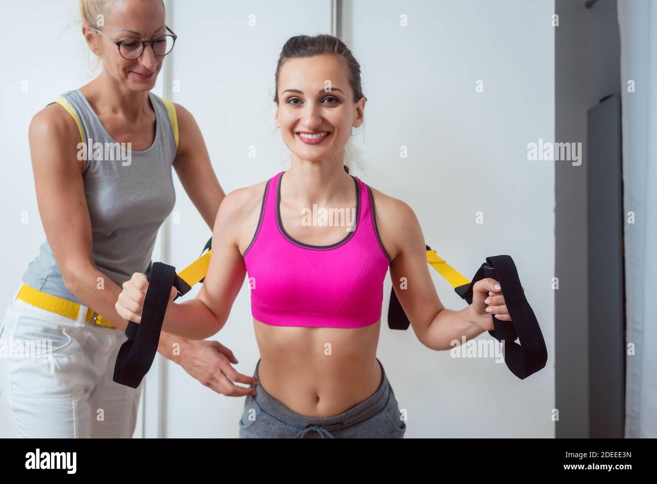 Woman using sling trainer during physical therapy to recover from an ...