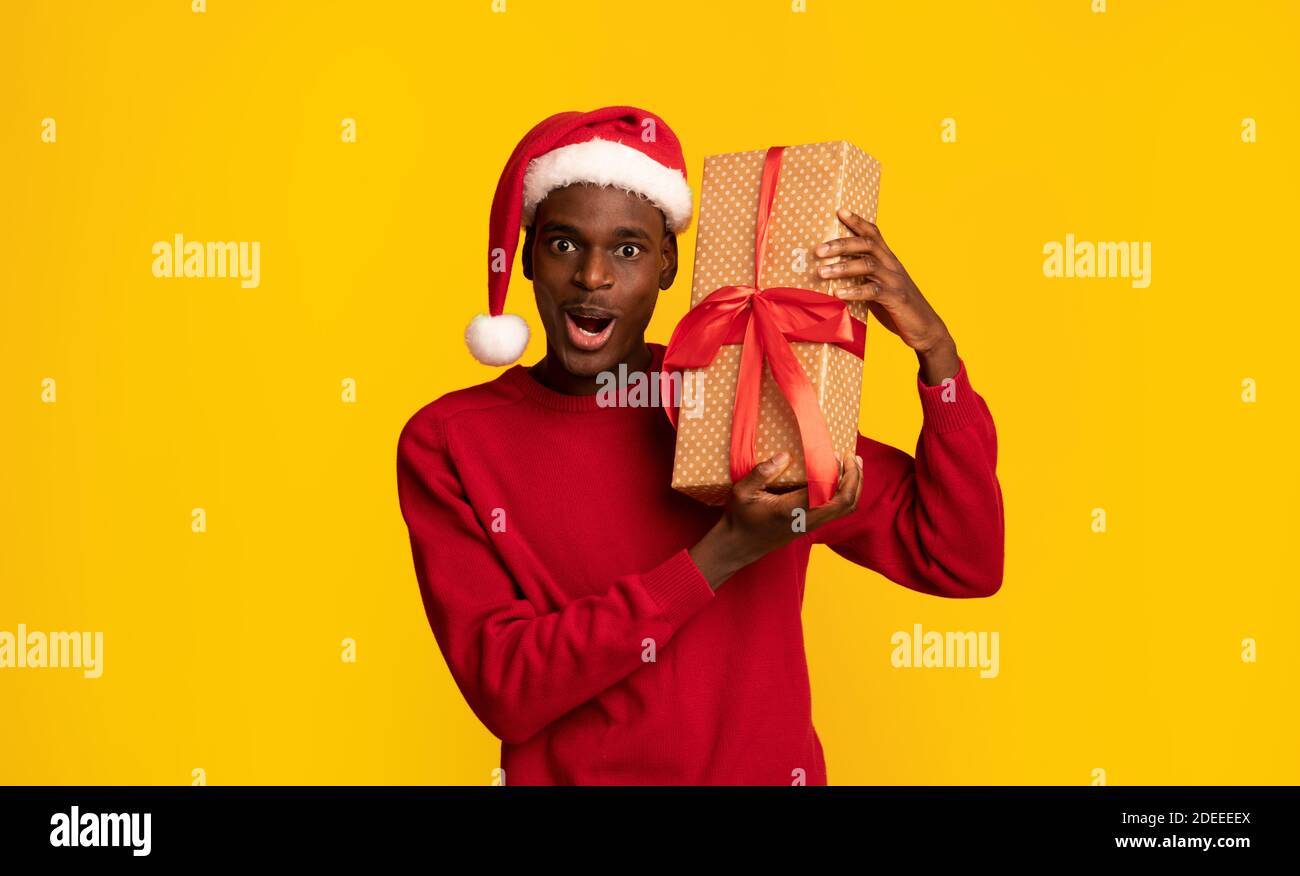 Xmas Present. Surprised Black Guy In Santa Hat Holding Christmas Gift ...