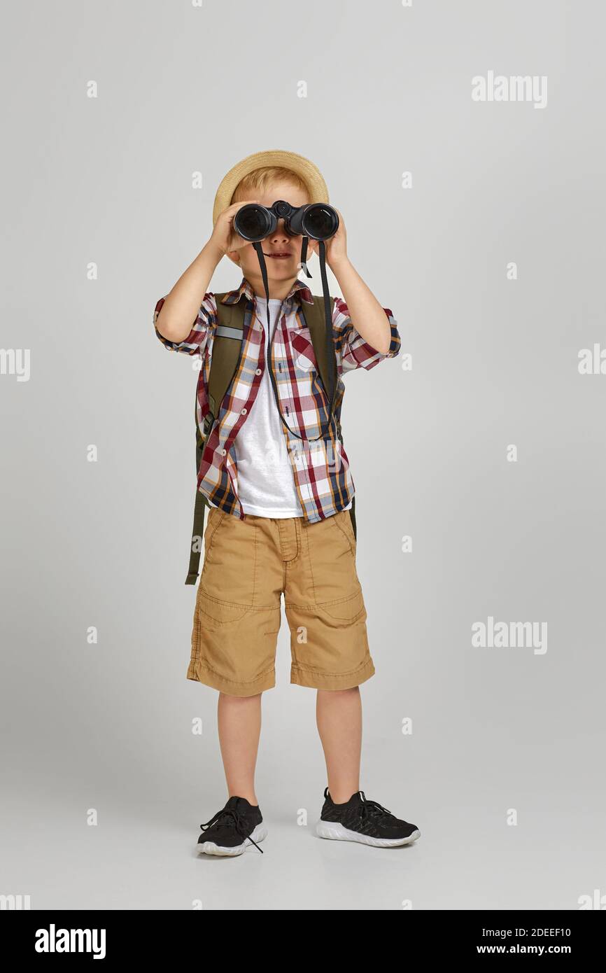 Little boy tourist with backpack looking through a binoculars. Little ...