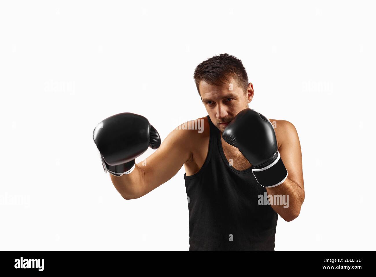 Handsome muscular man in black boxing gloves punching isolated on white ...