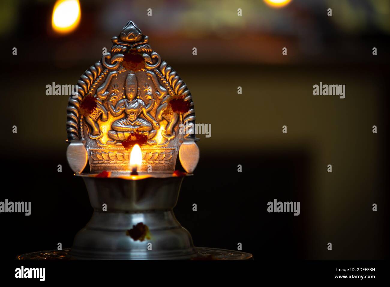 Close view of lit diya lamp. Lamp made out of silver metal lit during ...