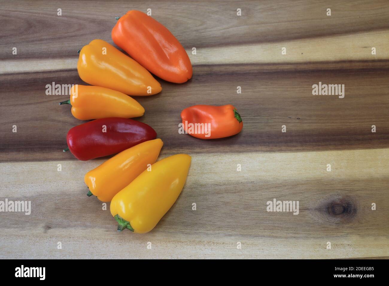 A few different colored peppers on a kitchen board Stock Photo - Alamy