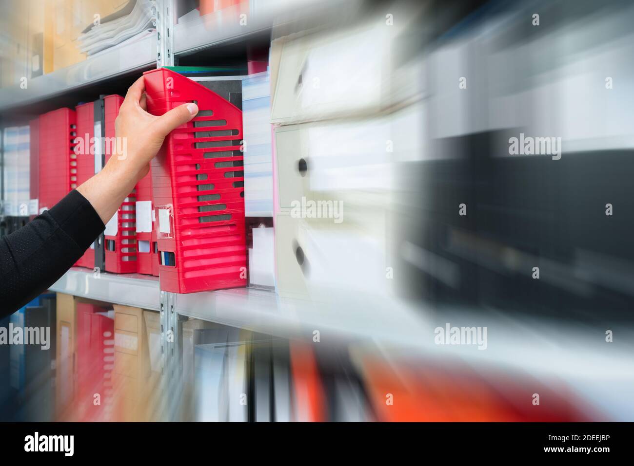 Mans hand picking a blank blind folder with files from the shelf ...