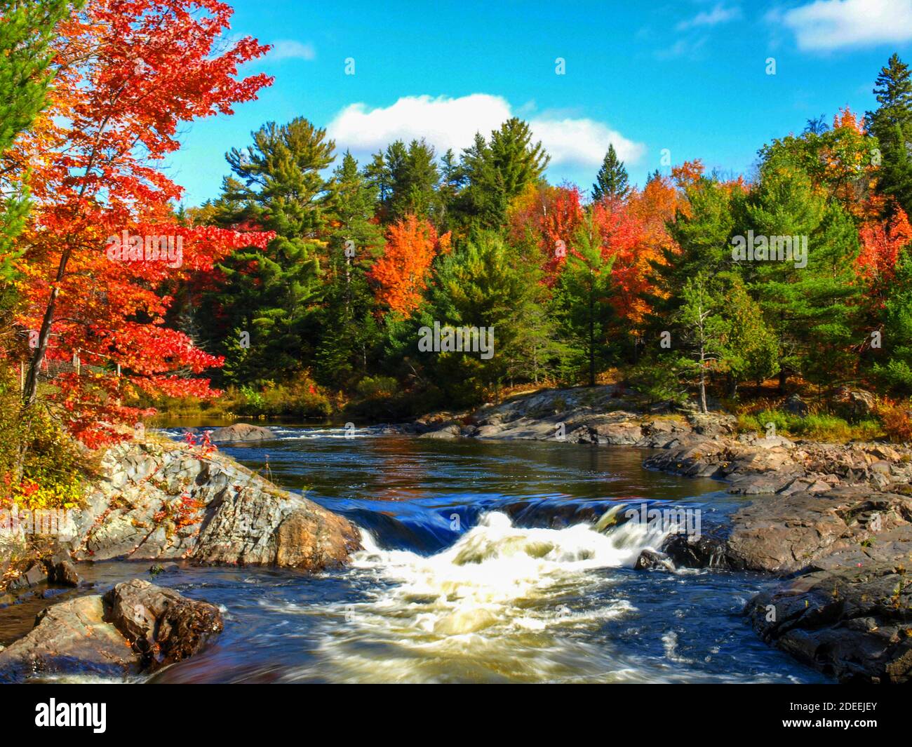 Gushing river decorated by the red foliage in fall, Chutes Prov Park ...