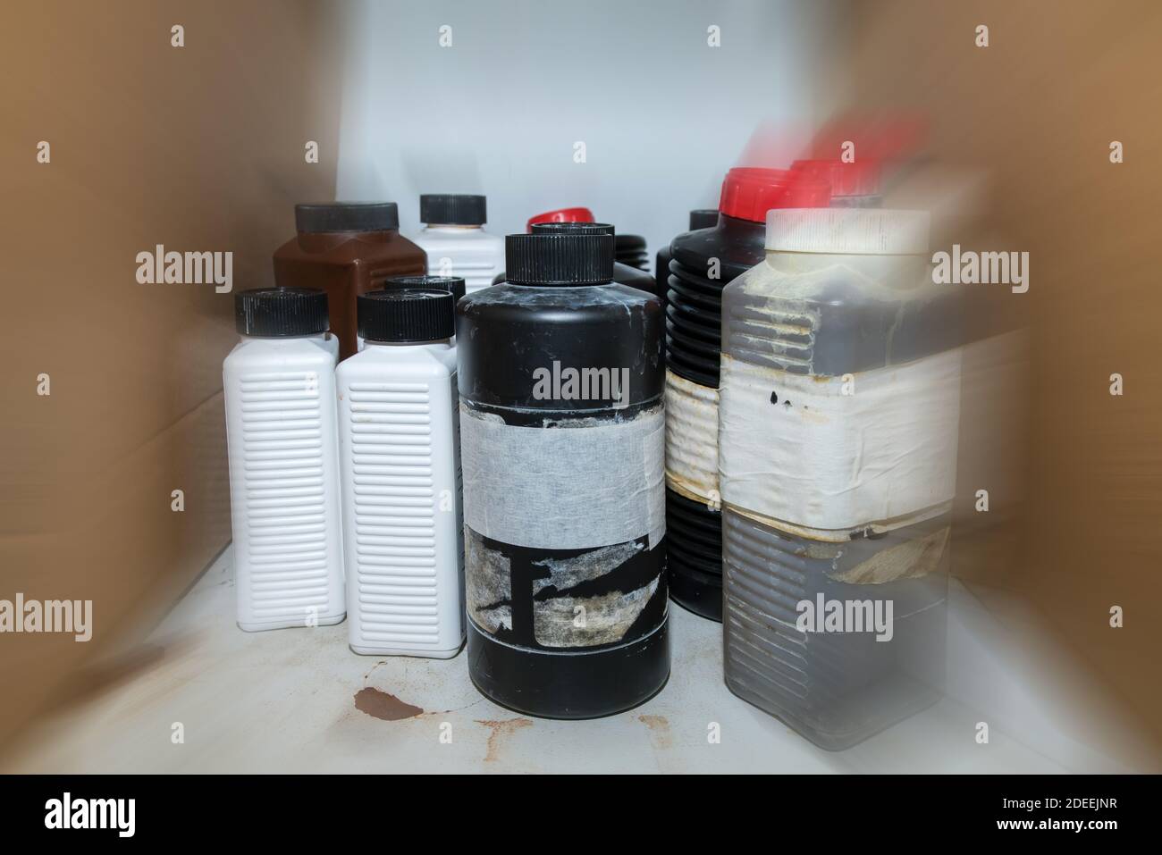 Flammable dangerous chemical in plastic bottle containers on a shelf in ...