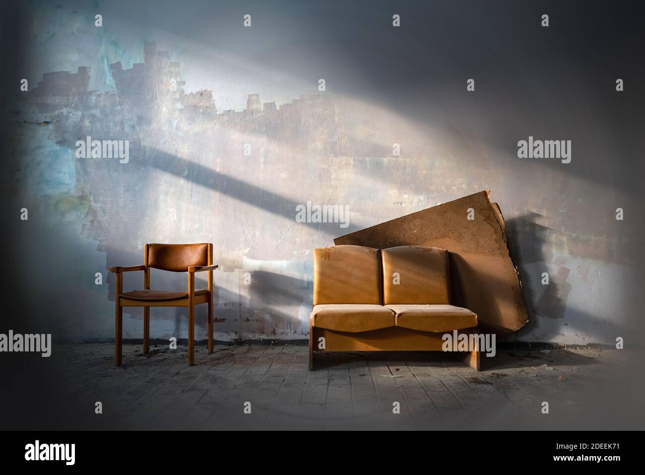 Old leather couch in abandoned factory building side lit by sun. Rustic ...