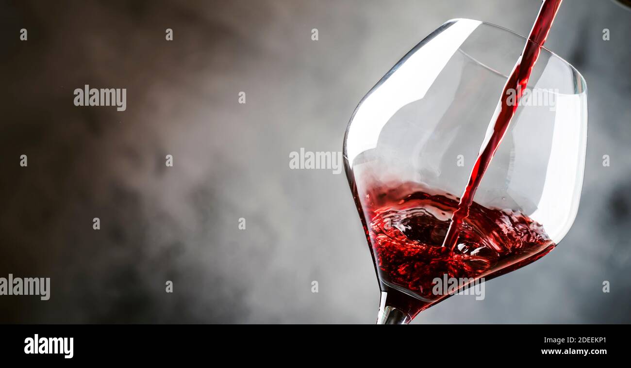 French dry red wine, pours into glass, gray background, banner ...