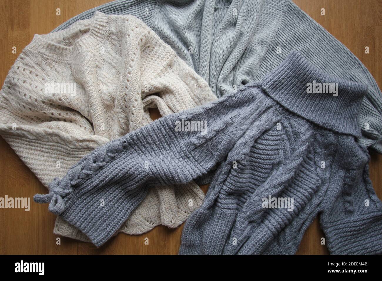 Three pastel warm sweaters for winter background. Women's stylish clothes. Cozy Winter look ...