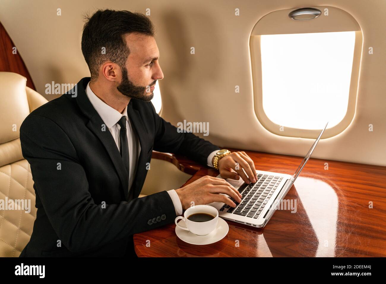 Handsome businessman wearing elegant suit flying on exclusive private ...