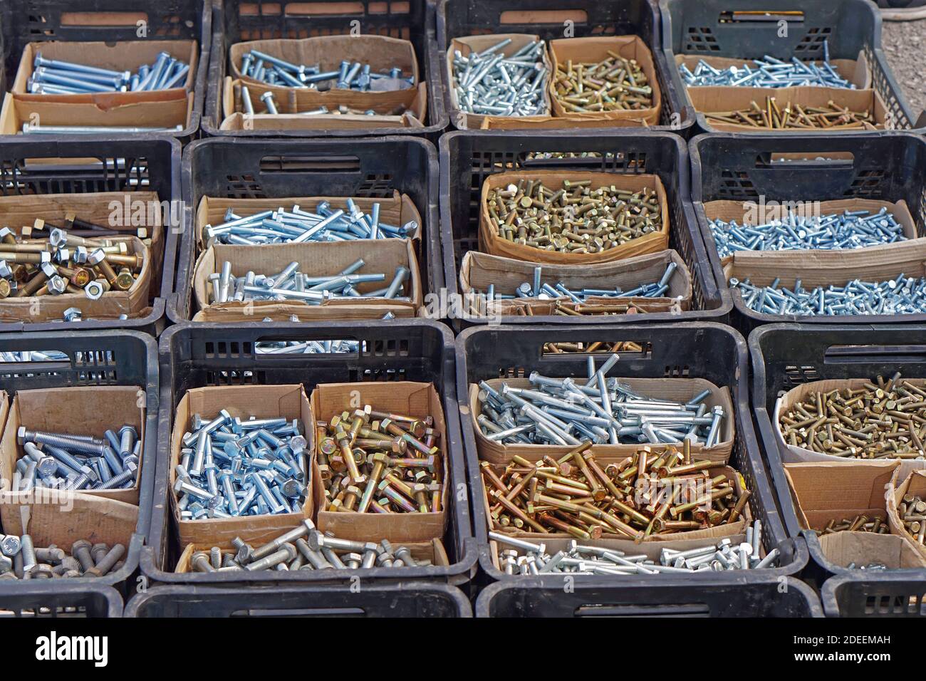Many new bolts in boxes and crates hardware Stock Photo - Alamy