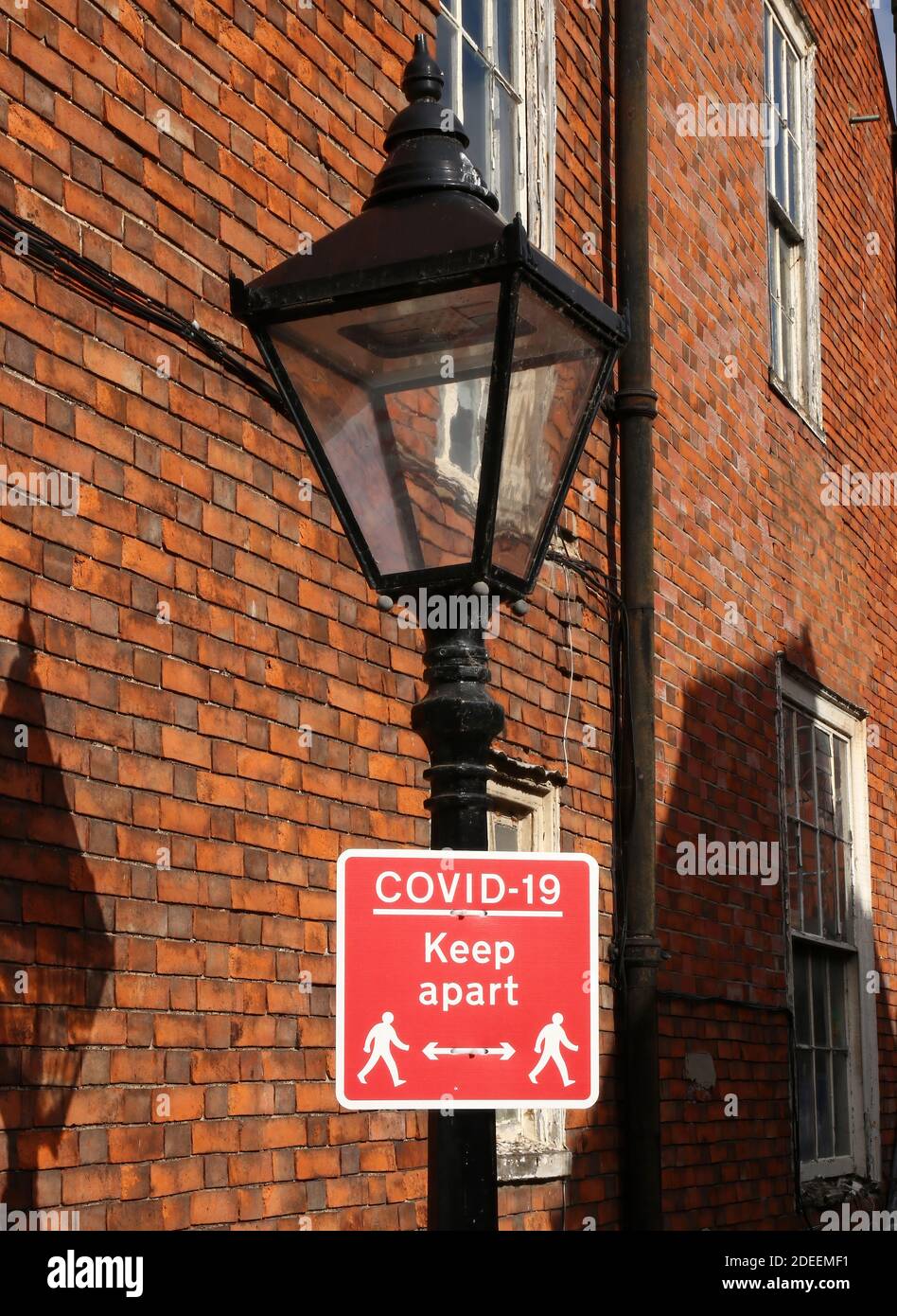 Red and white Covid-10 warning sign, instructing people to keep a safe ...