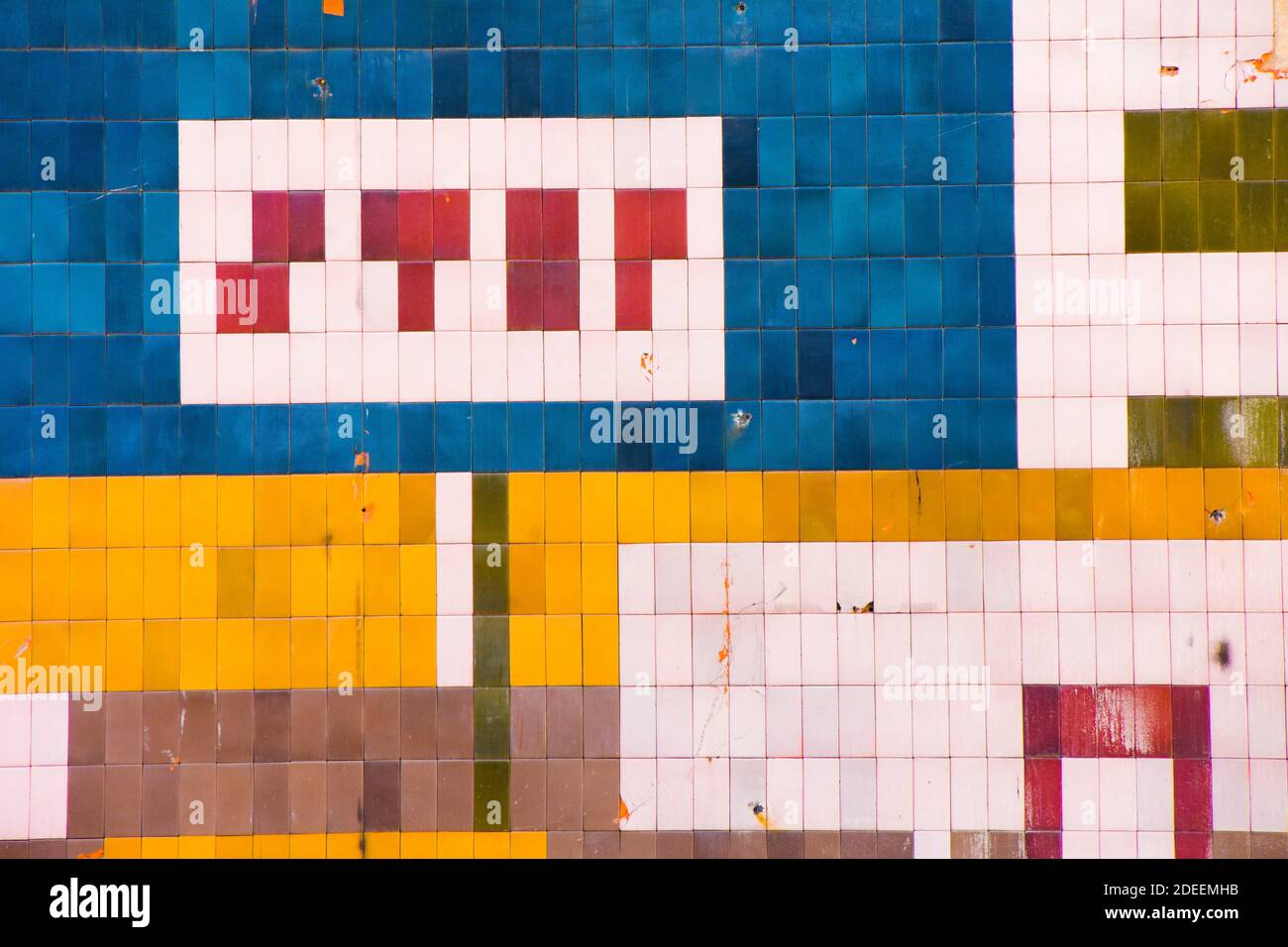 Stop word in red tiles. Wall covered of colored tiles in blue, yellow ...
